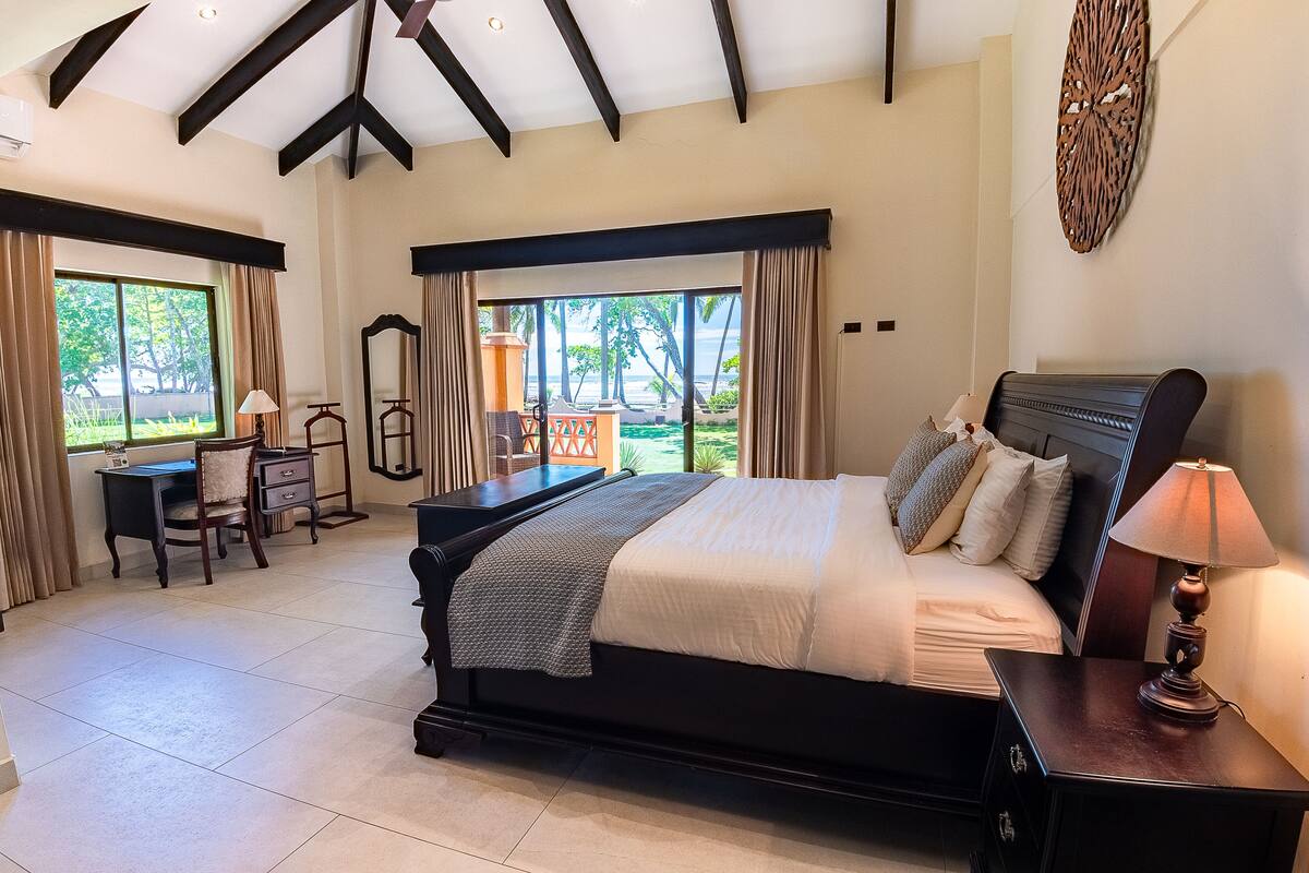 Quarto espaçoso com uma cama grande, uma escrivaninha e uma cadeira, com vista para o exterior.