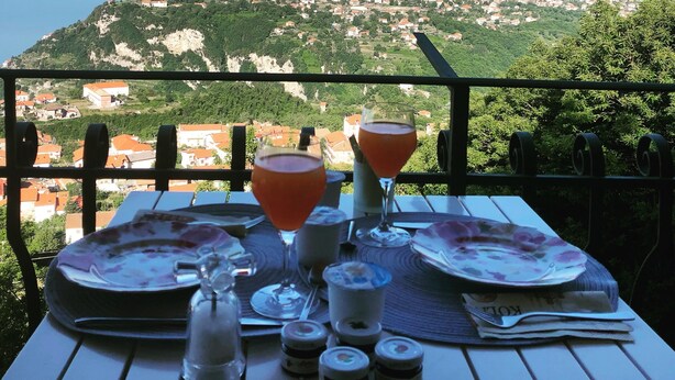 Mesa posta para dois com vista para uma paisagem montanhosa.