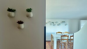 Uma área de refeições com uma mesa branca e cadeiras de madeira.