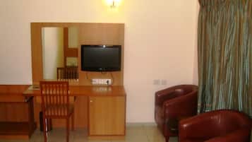 Quarto casal luxo, 1 cama Queen | Área de estar | TV