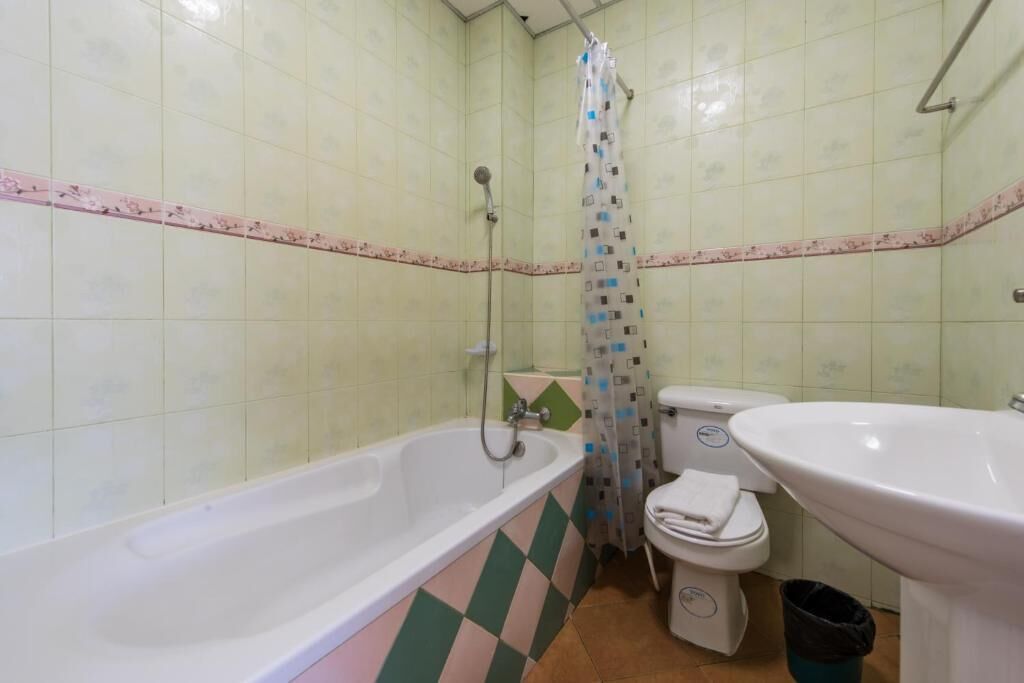 Casa de banho com banheira, sanita e lavatório.