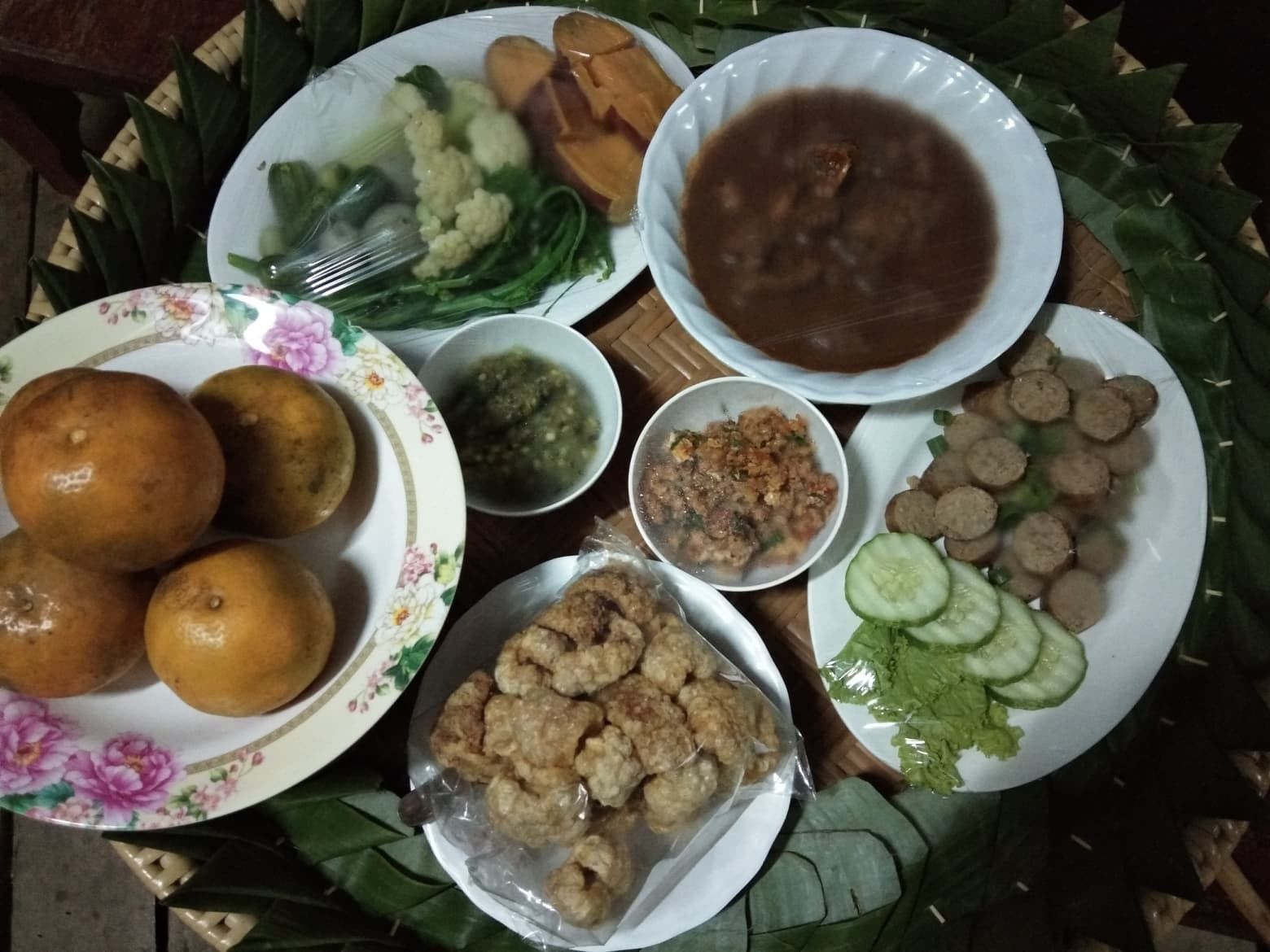 Uma mesa com diversos pratos, incluindo legumes, carne e uma tigela de sopa.