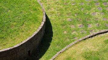 Muro de pedra com uma área gramada ao lado.