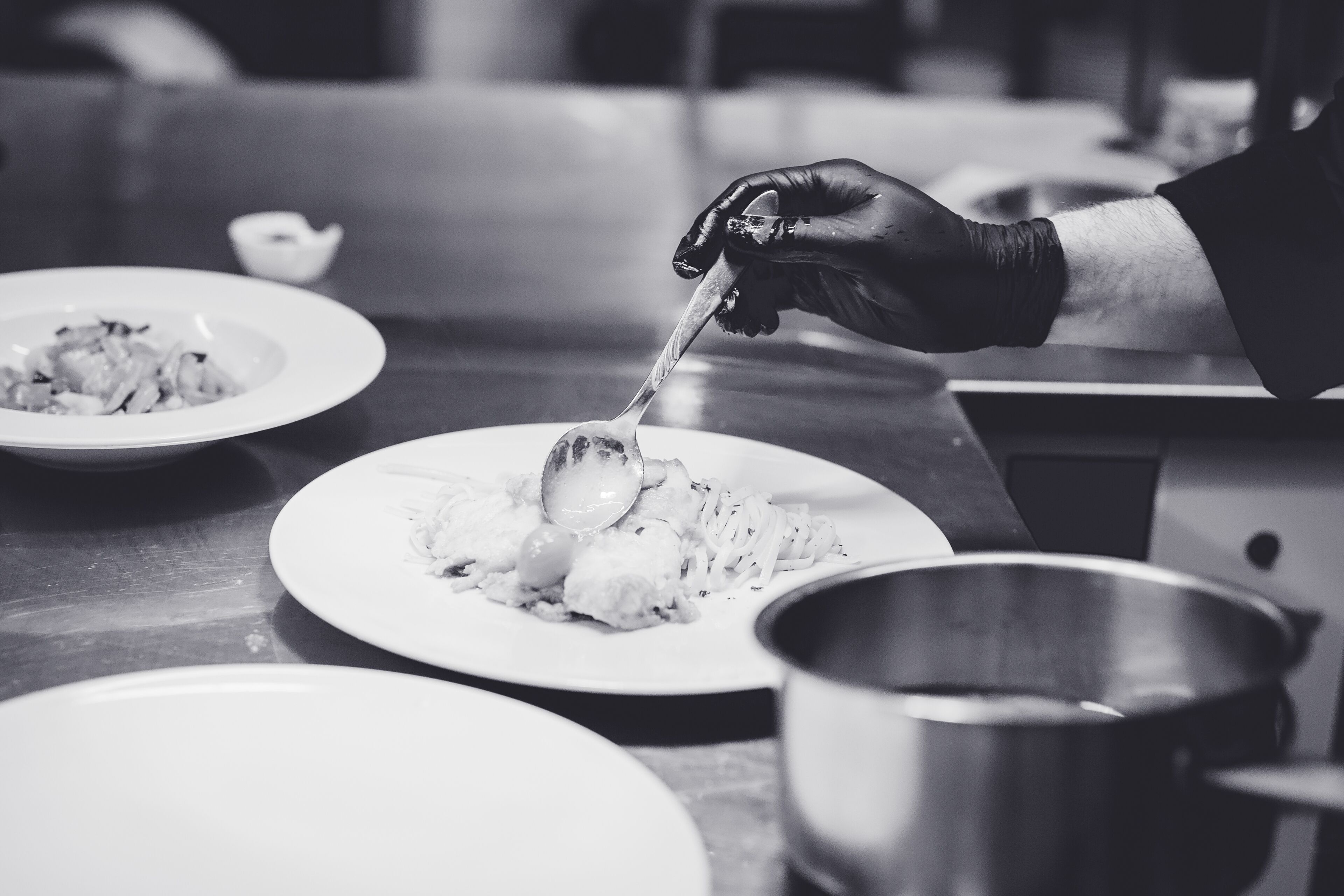 Alguém servindo comida de uma panela para um prato.