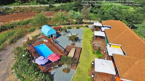 Vista aérea de um resort com piscina, escorrega aquático e vários quartos de hóspedes.