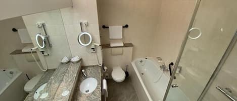 Casa de banho moderna com toucador em mármore, banheira e cabine de duche em vidro.