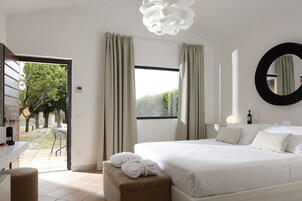 Quarto com cama, espelho redondo e vista para o exterior.