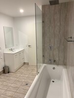 Apartamento Deluxe, 1 quarto (Non pet friendly) | Casa de banho | Uma combinação polibã/banheira, artigos de higiene pessoal grátis 
