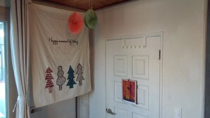 Quarto com porta branca, um lampião de papel pendurado e um enfeite de parede com design festivo.