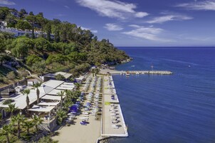Uma praia privada, espreguiçadeiras, guarda-sóis de praia 