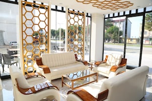 Um interior moderno com um sofá branco, poltronas de couro e uma mesa de centro de vidro.