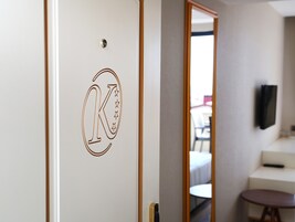 Quarto de hotel com porta e design monogramado.