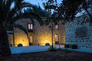 Pátio de pedra com bancos e um poste de luz.