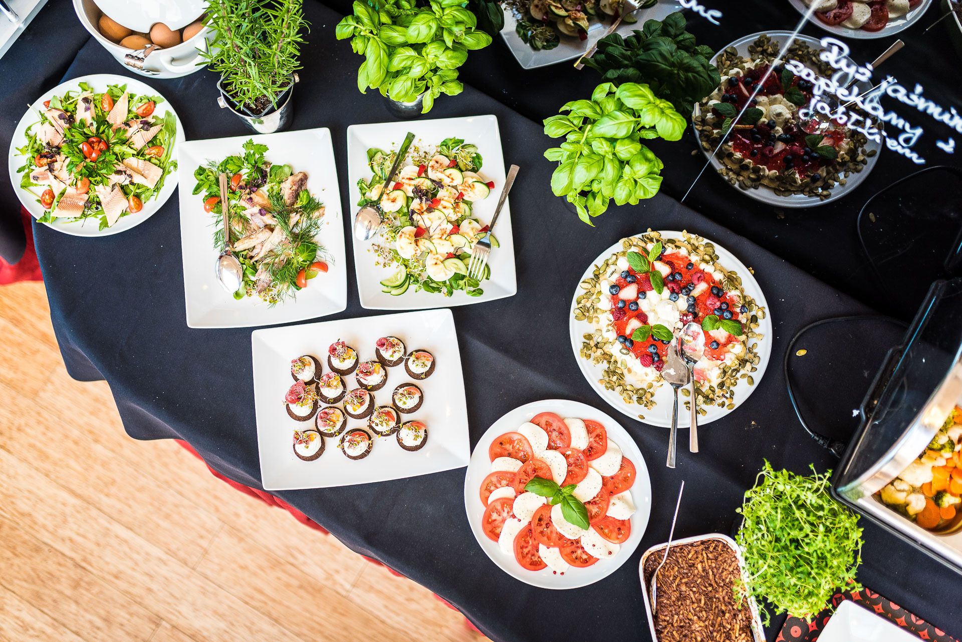 Diversos pratos em uma mesa, incluindo saladas, aperitivos e uma sobremesa.
