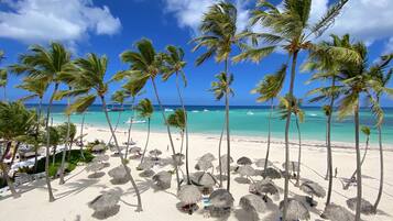 Uma praia privada, espreguiçadeiras, guarda-sóis de praia