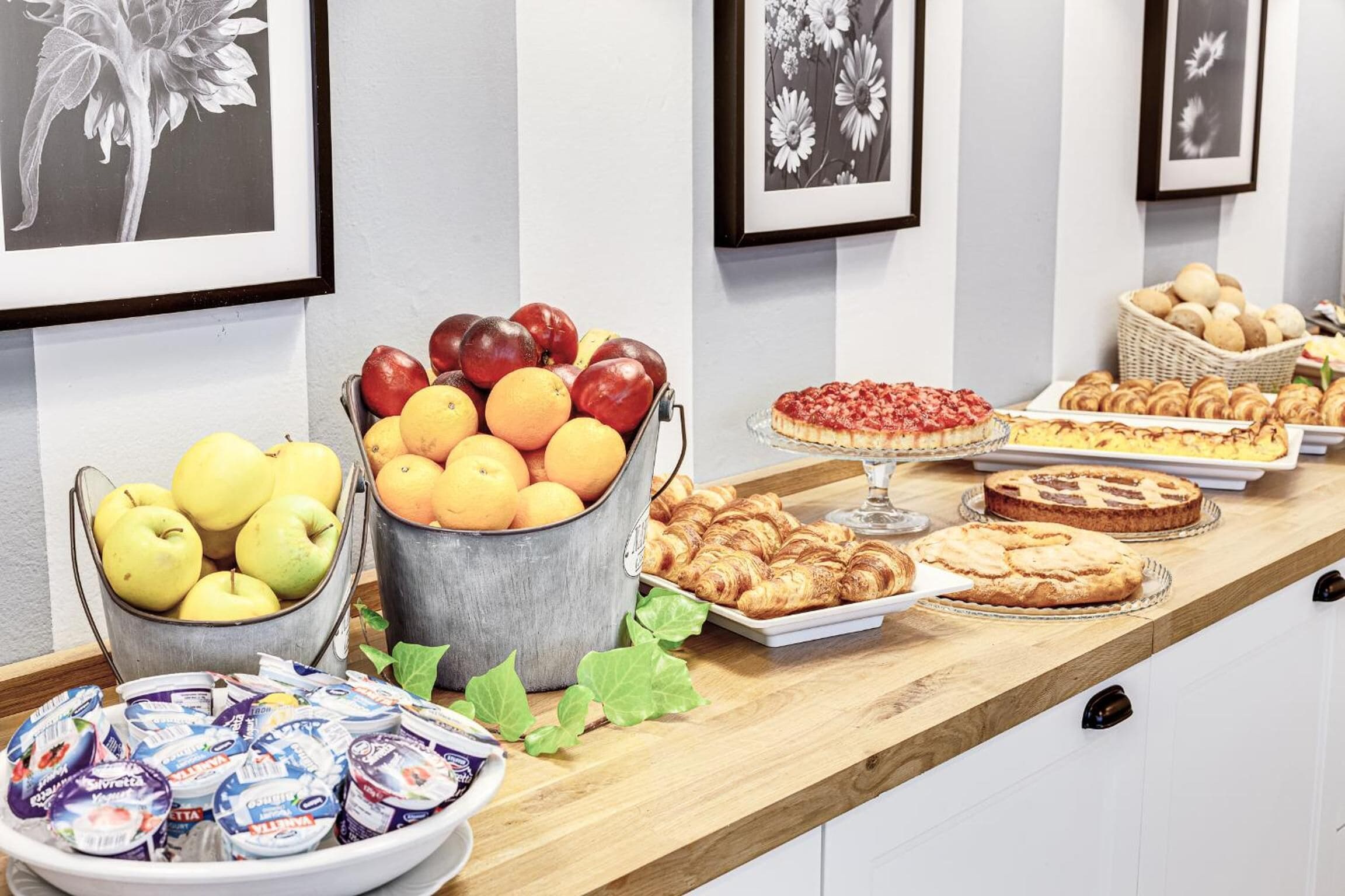 Mesa de buffet com frutas, pastelaria e iogurte.