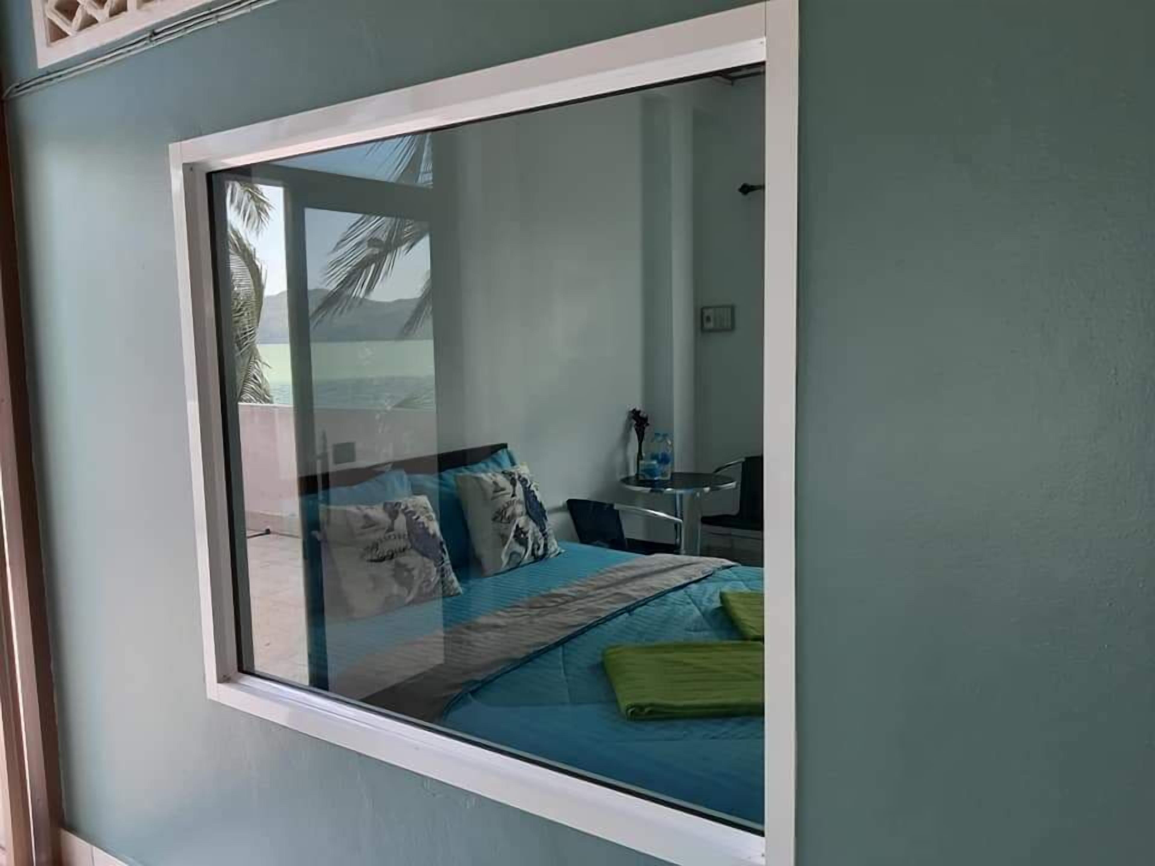 Quarto com cama, almofadas, mesa pequena e cadeira.