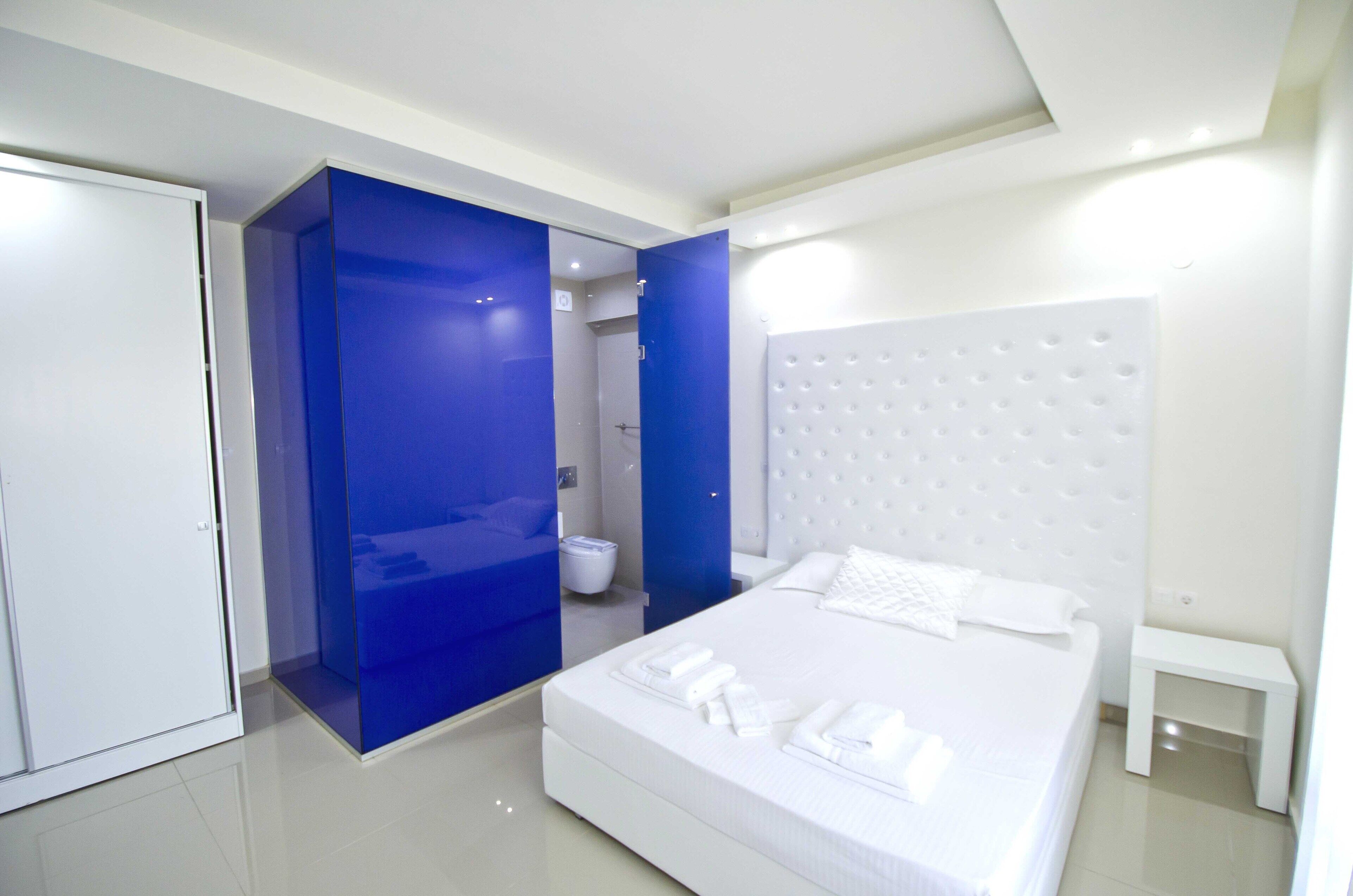 Quarto moderno com uma cama grande, um guarda-roupa e zona de duche.