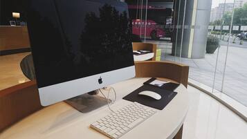 Um espaço de trabalho moderno com um computador de mesa, teclado e rato numa mesa curva.