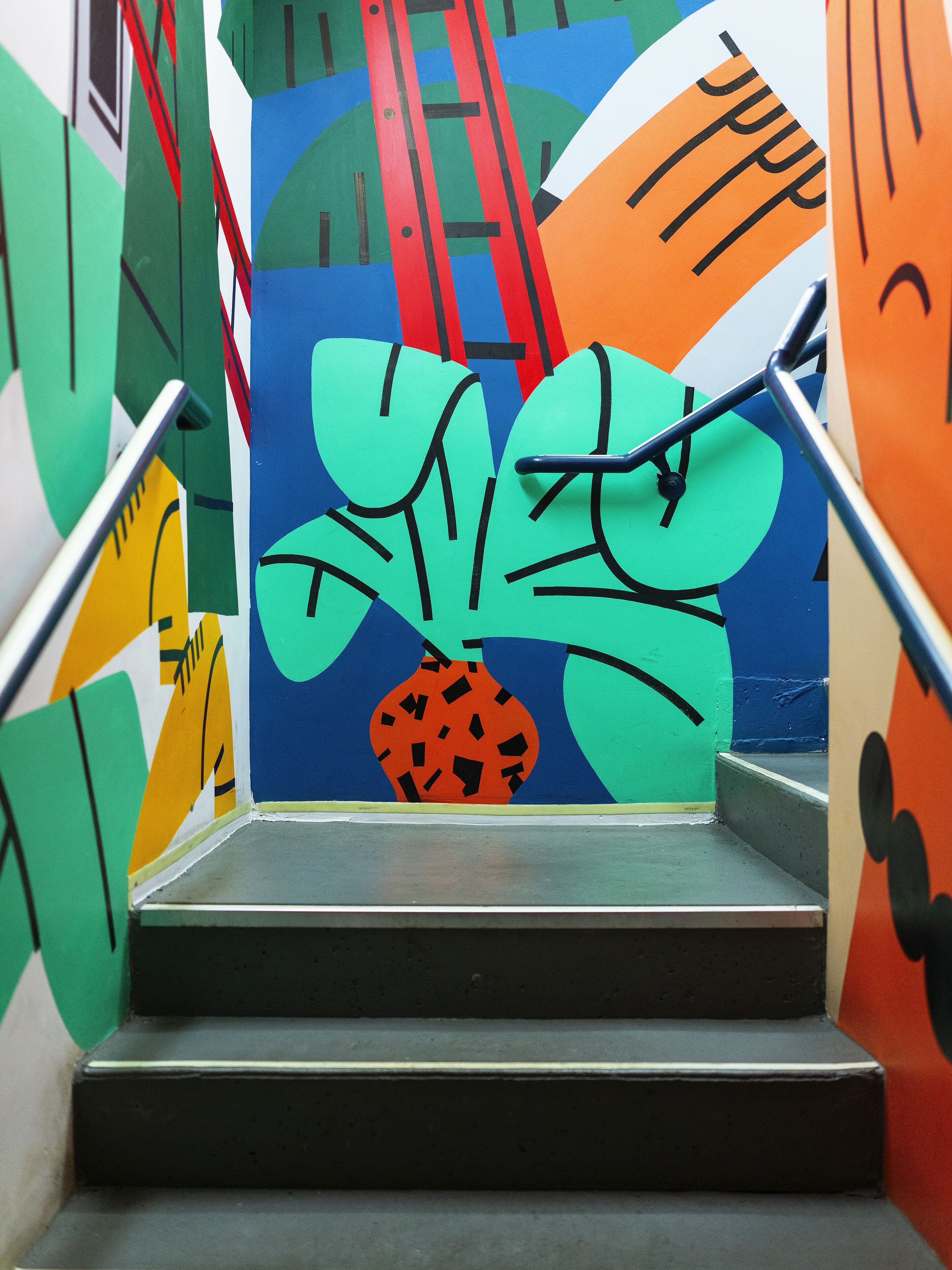 Uma escadaria com paredes coloridas pintadas à mão e um desenho de abacaxi.