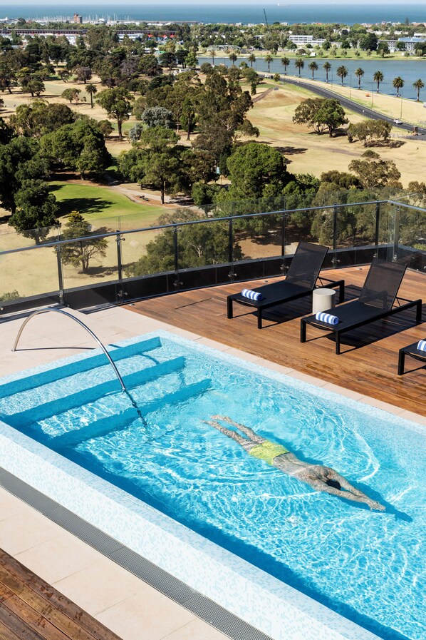 Piscina com vista para um campo de golfe e um corpo d'água.