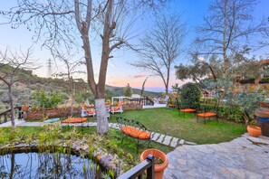 Um quintal com piscina, área de estar e um pergolado.