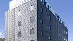 Um edifício de hotel moderno com fachada em padrão quadriculado e grandes janelas.