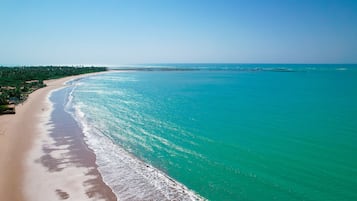 Na praia, espreguiçadeiras, guarda-sóis, toalhas de praia