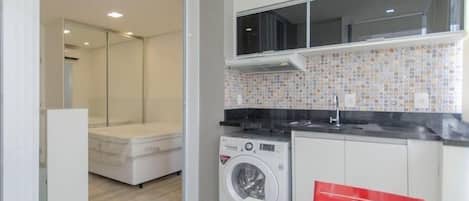 Um frigorífico, um micro-ondas, um forno, uma cafeteira/bule