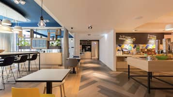 Um interior moderno com área de refeições, cozinha e bar.