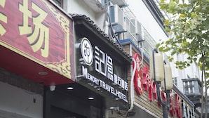Um hotel com uma placa de destaque em inglês e chinês, indicando que é um hotel Memory Travel.
