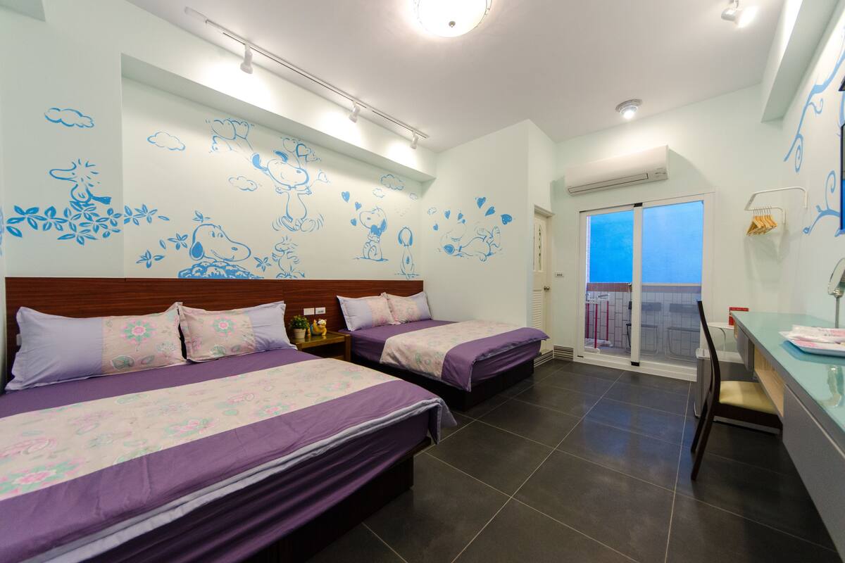 Quarto de hotel com duas camas, banheiro e varanda.