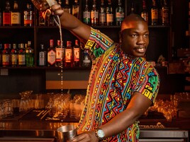 Um bartender a servir uma bebida num coqueteleira.