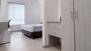 Quarto moderno com cama, guarda-roupa e área de trabalho.