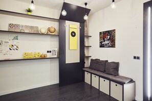 Decoração moderna com esquema de cores preto e branco, um banco com almofadas e obras de arte nas paredes.
