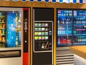 Máquina de vendas com diversas opções de bebidas e alguns lanches.