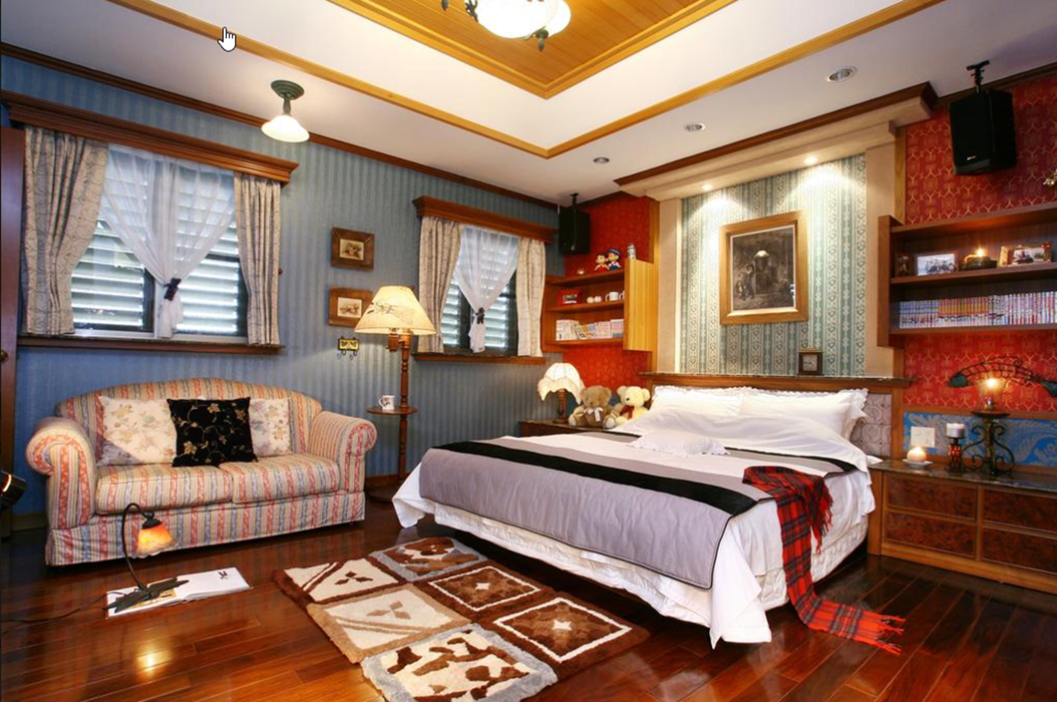 Um quarto aconchegante com uma cama, um sofá, uma luminária e uma estante de livros.