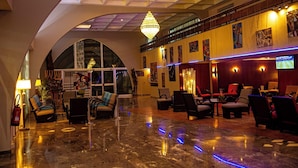 Um hall amplo com teto alto, um lustre e áreas de estar.
