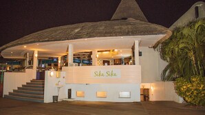 Um edifício com telhado cônico e uma placa com a inscri ção 'Sika Sika'.