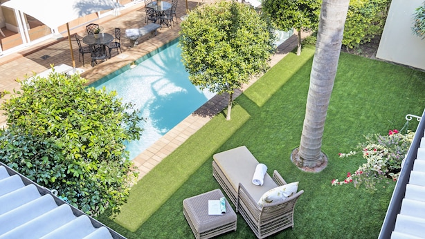 Área de piscina no terraço, com espreguiçadeira, mesa pequena e uma cadeira.