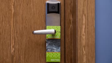 Uma porta com puxador metálico e etiqueta verde com texto branco.