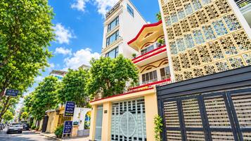 Um hotel com fachada tradicional, entrada por portão e placa indicando o nome.