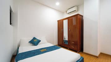Quarto com cama, guarda-roupa e ar condicionado.