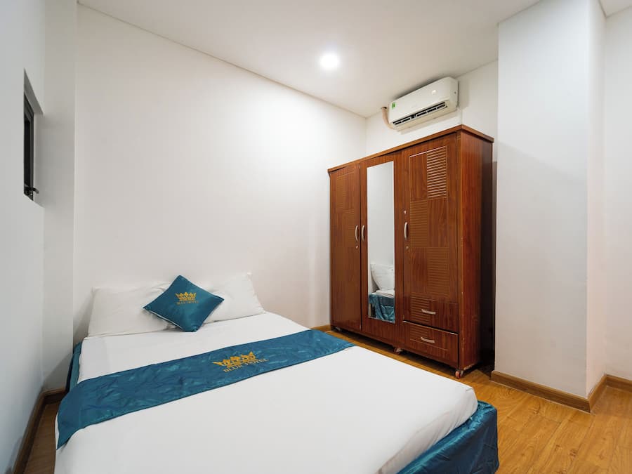 Quarto com cama, guarda-roupa e ar condicionado.