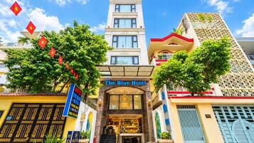 Hotel Azul com uma entrada marcante, uma escadaria visível e vista clara dos edifícios ao redor.