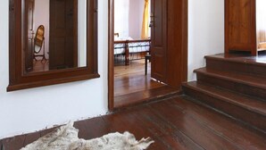 Quarto com piso de madeira, um espelho grande e um tapete de pele.