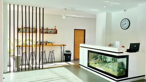 Cozinha moderna com aquário embutido, área de jantar com banquetas e um relógio na parede.