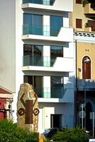 Um edifício moderno, de vários andares, com varandas e grandes janelas.