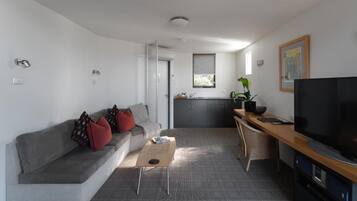 Uma sala de estar moderna com sofá, mesa de centro e televisão.