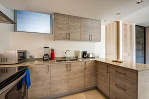 Apartamento, 2 quartos | Cozinha privada | Um frigorífico, um micro-ondas, um forno, uma placa de cozinha 